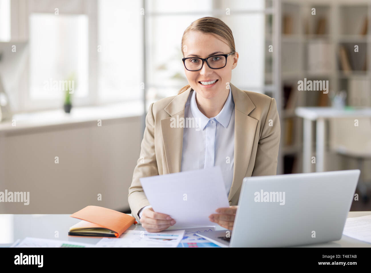 Cheerful financial employee examining report Stock Photo - Alamy