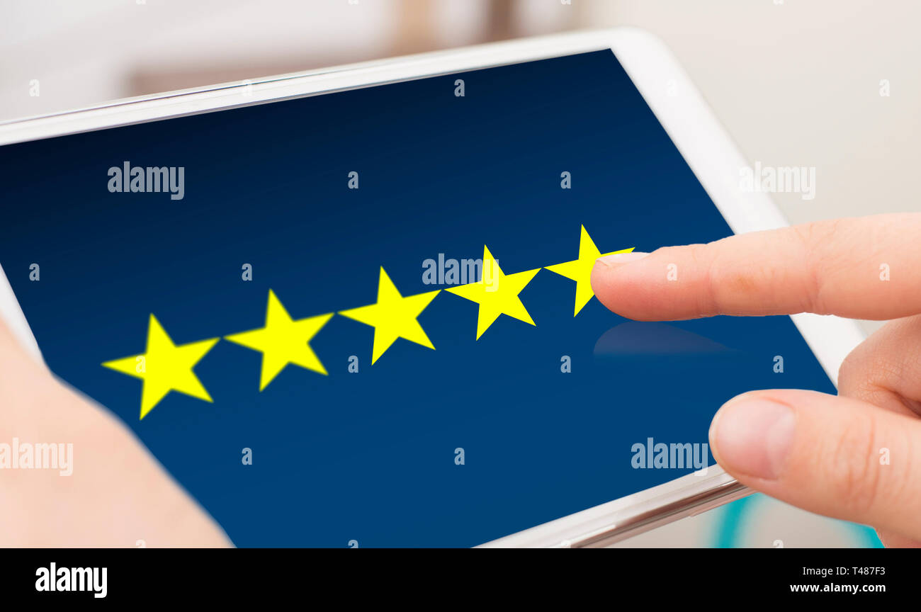 customer marking customer satisfaction survey on tablet. touch five ...