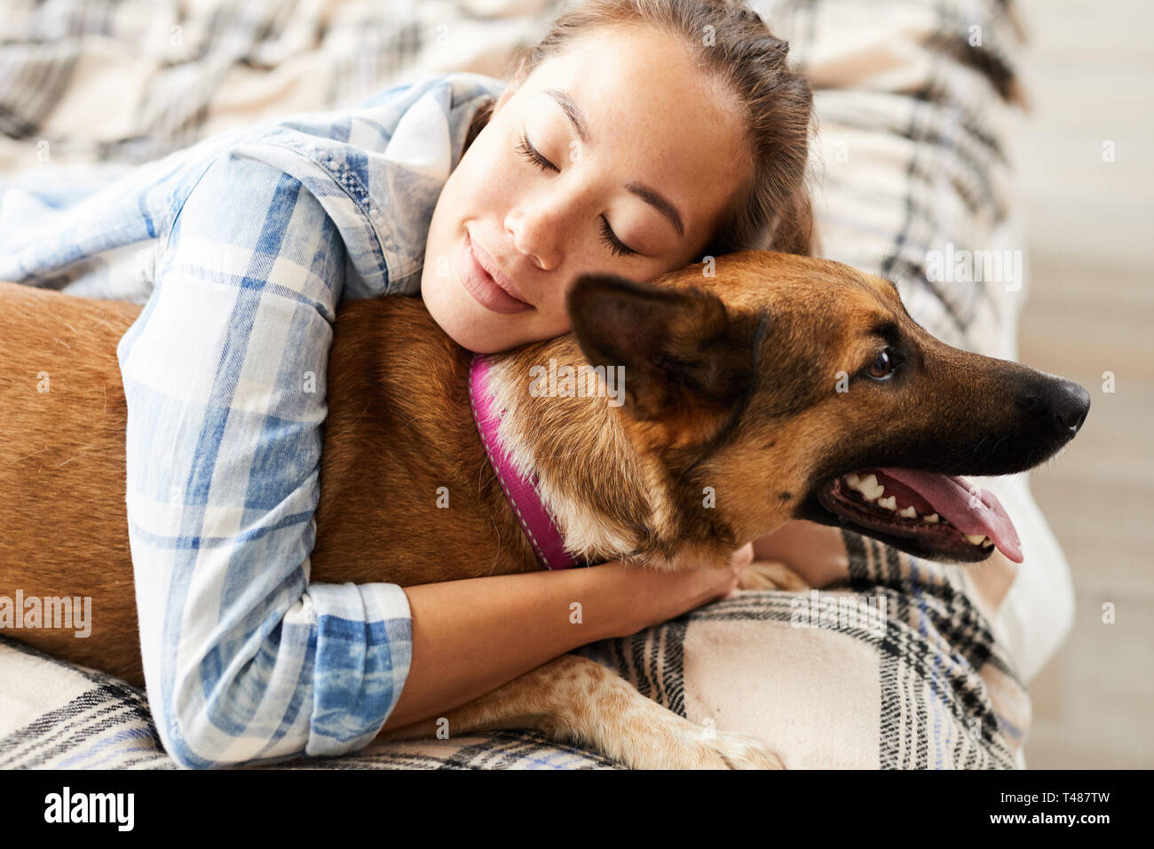 Asian Woman Embracing Dog Stock Photo - Alamy