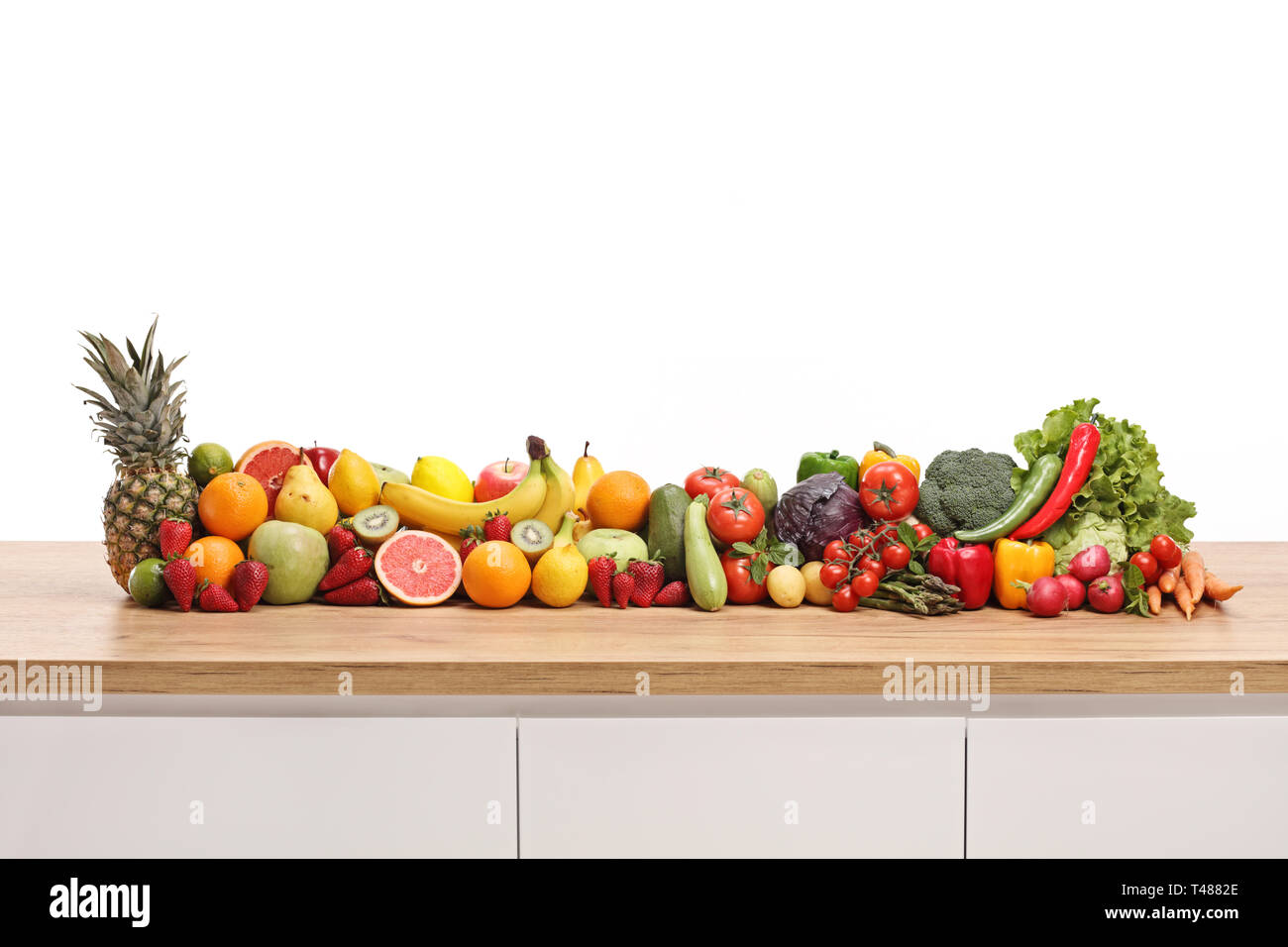 Variety of fruits and vegetables on a wooden counter isolated on white ...