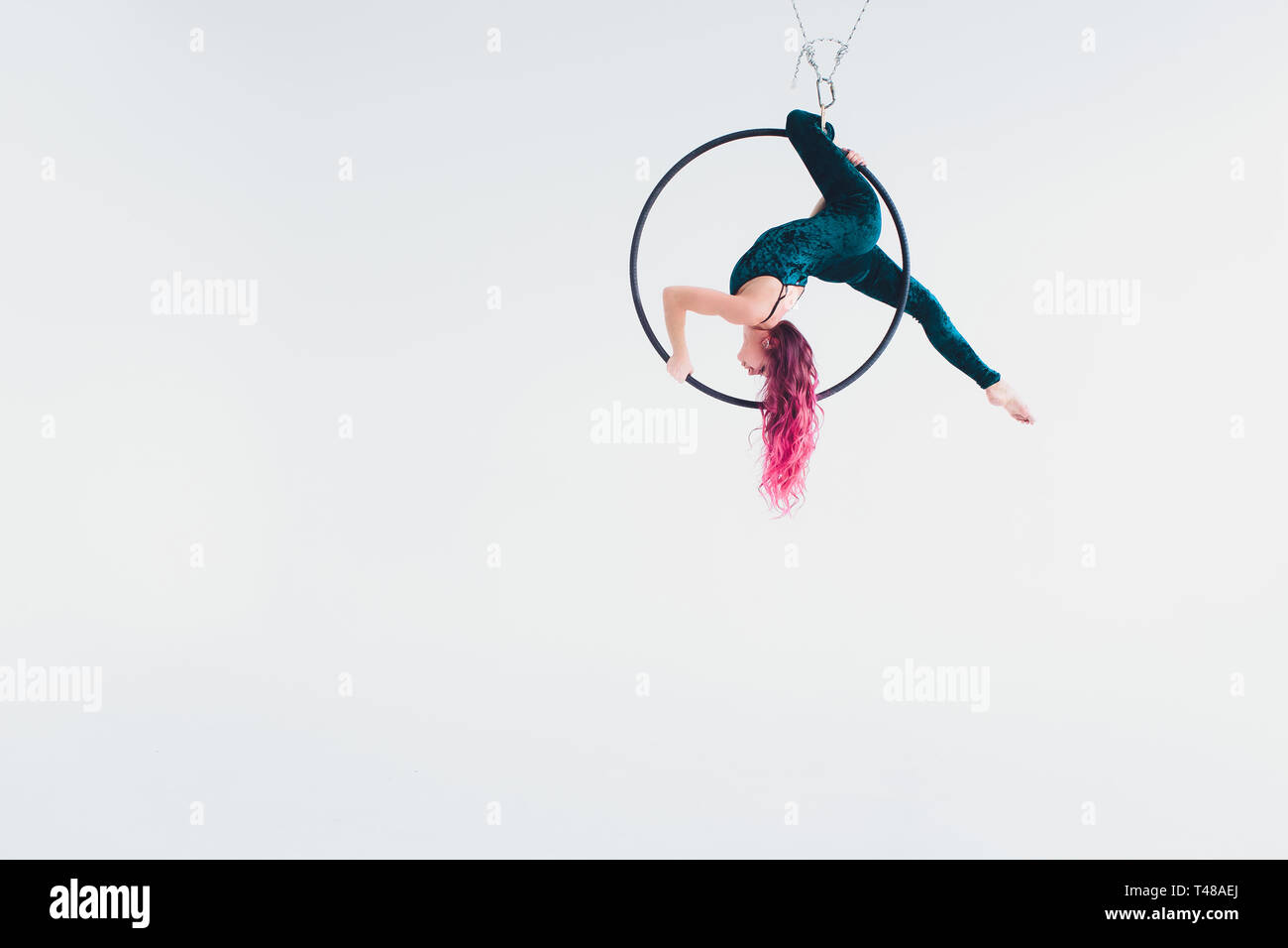 A young girl performs the acrobatic elements in the air ring. Studio ...