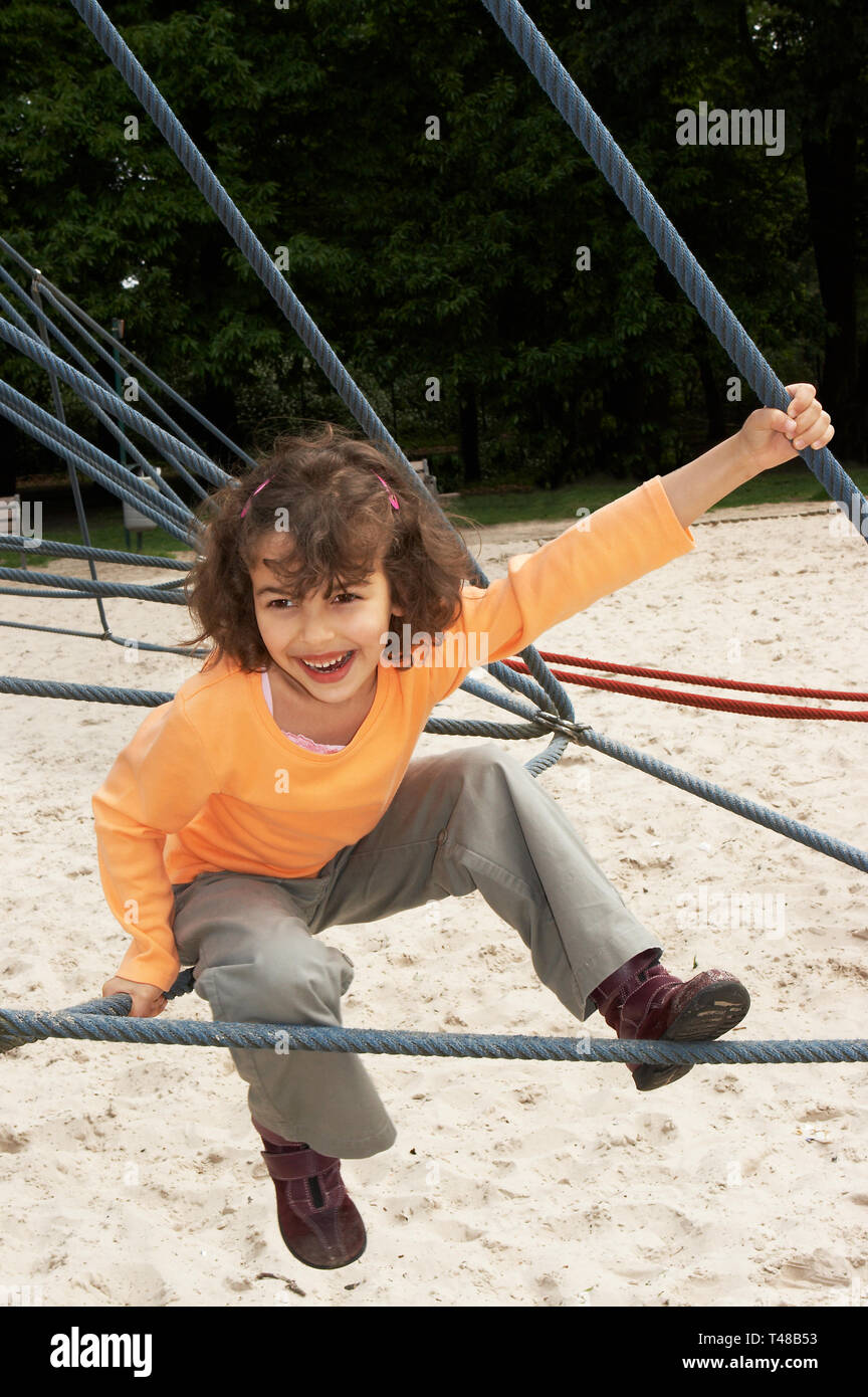 Little girl on a climbing frame at the playground Stock Photo - Alamy