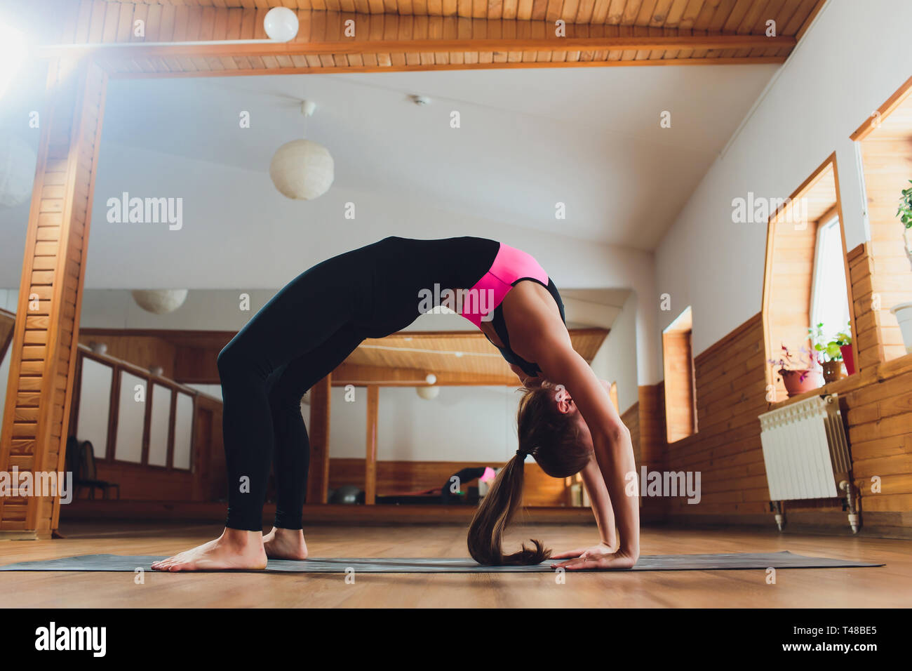 Beautiful woman practices backbend yoga asana Urdhva Dhanurasana ...