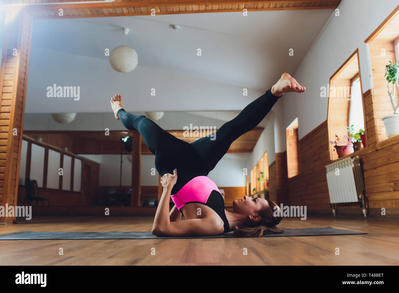 Young sporty attractive woman practicing yoga, doing Salamba ...