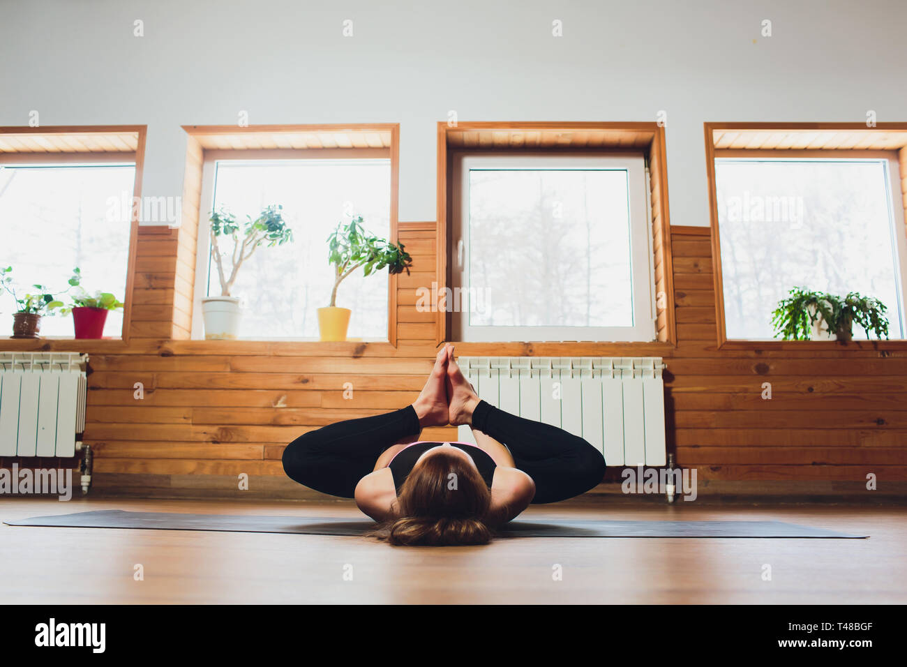 Sporty woman practicing yoga, doing Ardha Padmasana exercise, Half ...