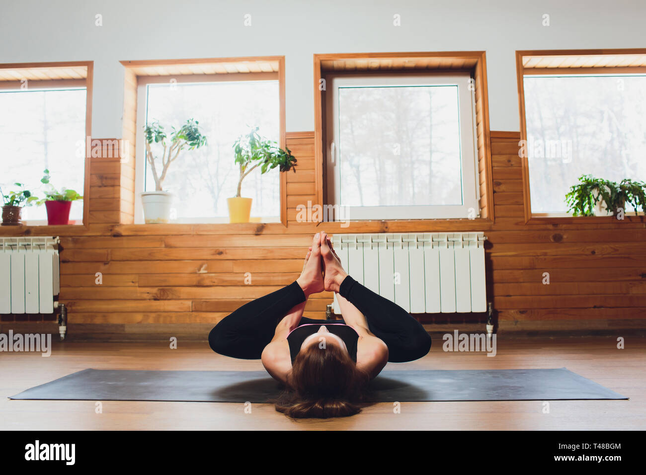 Sporty woman practicing yoga, doing Ardha Padmasana exercise, Half ...