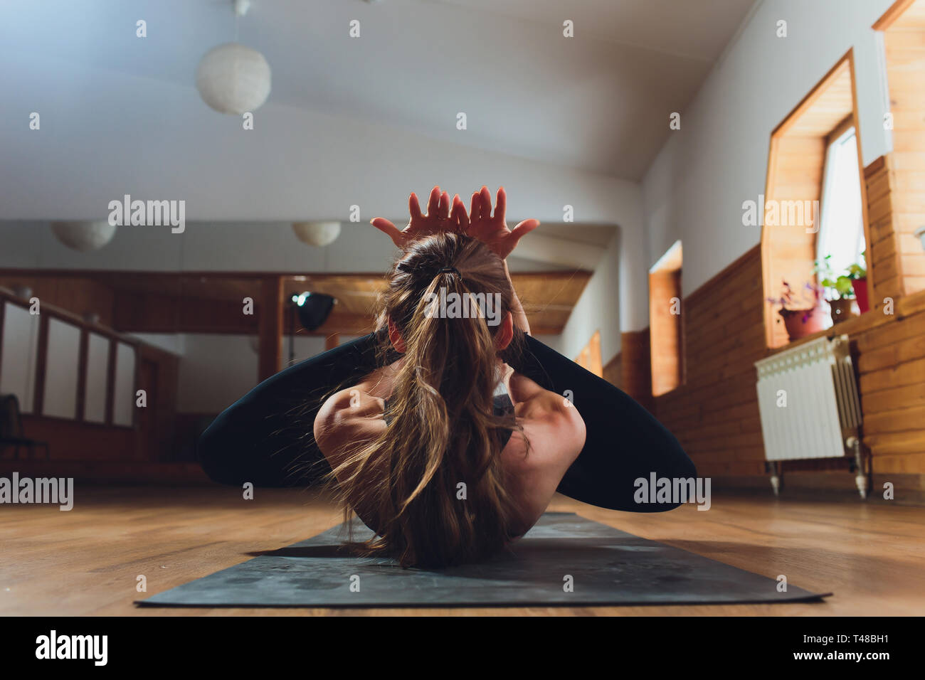 Sporty woman practicing yoga, doing Ardha Padmasana exercise, Half ...