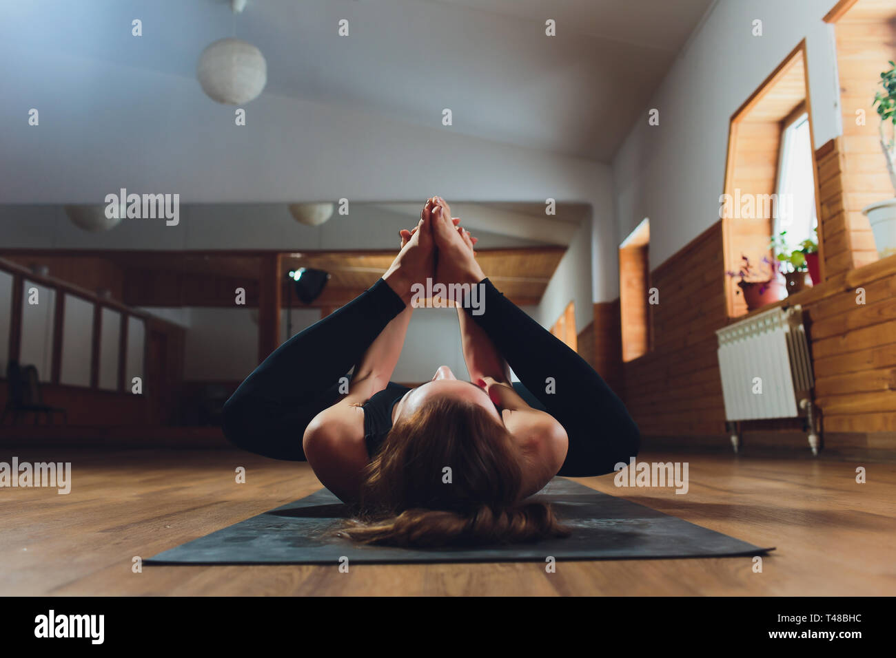Sporty woman practicing yoga, doing Ardha Padmasana exercise, Half ...