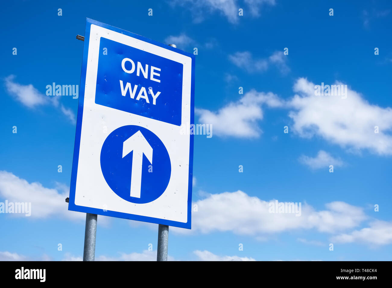 One way directional arrow sign against blue sky Stock Photo - Alamy