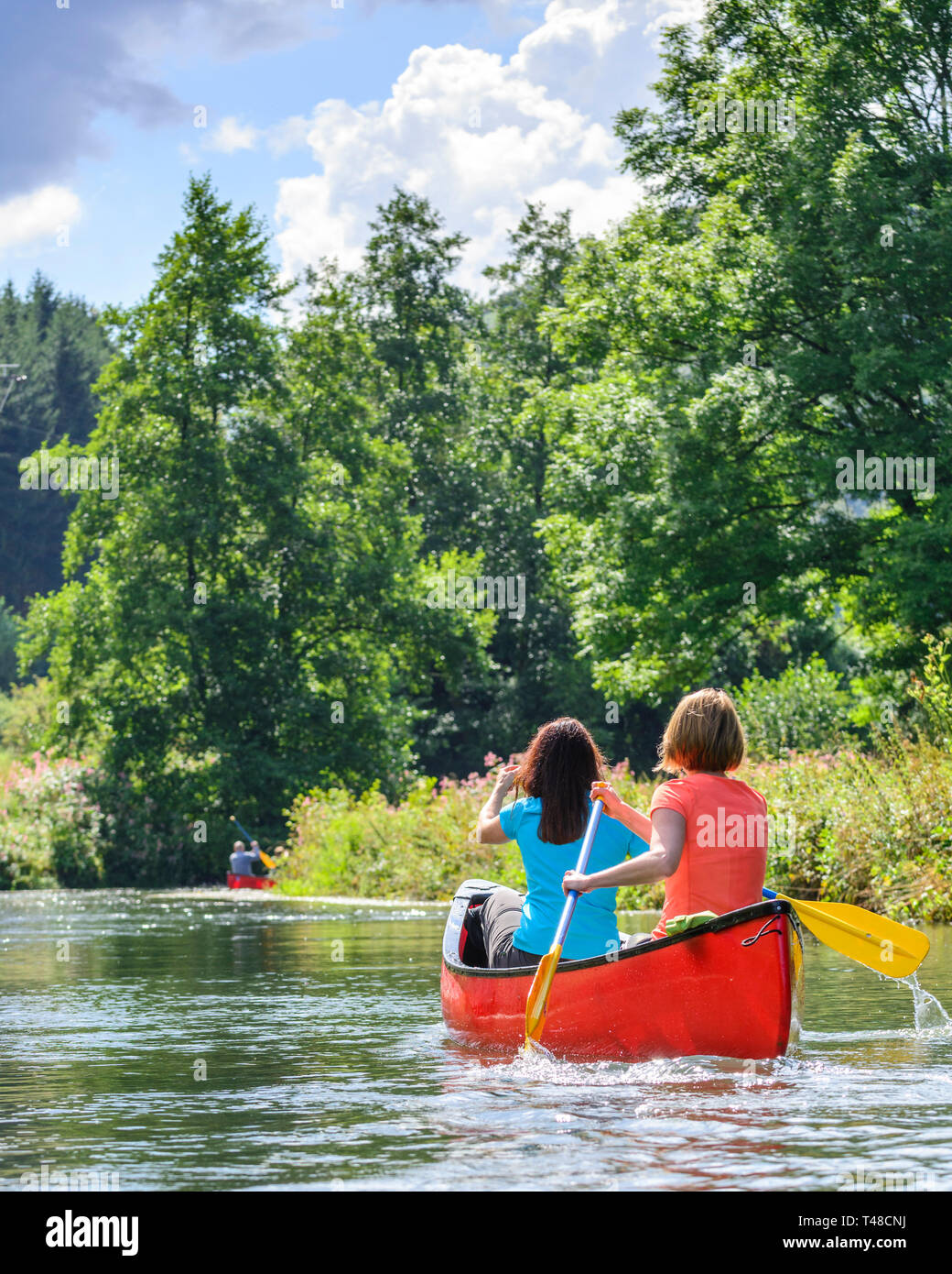 Two women paddling in canoe on small river Stock Photo - Alamy