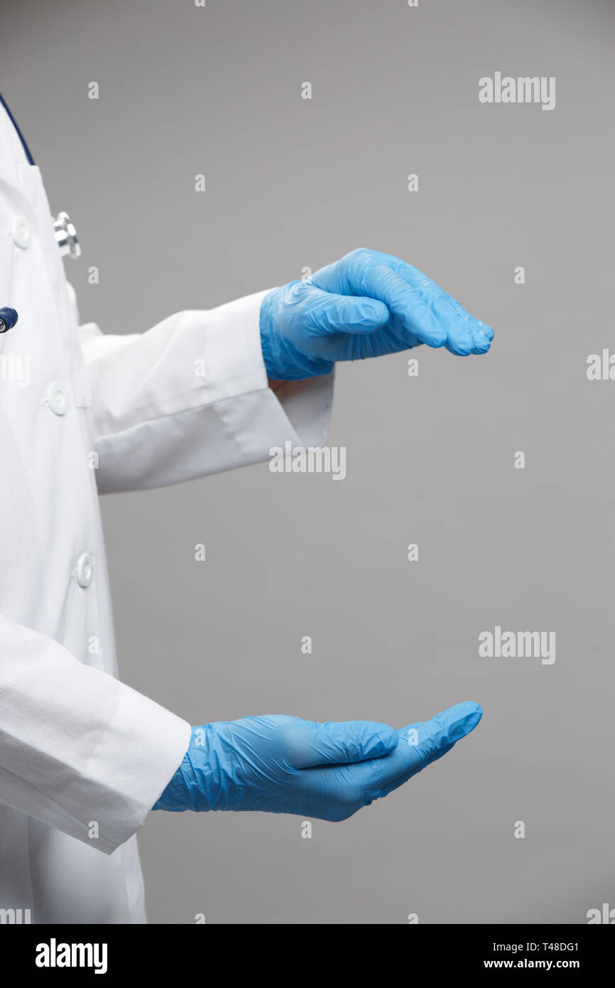 Photo of doctor with phonendoscope in blue rubber gloves holding hand ...