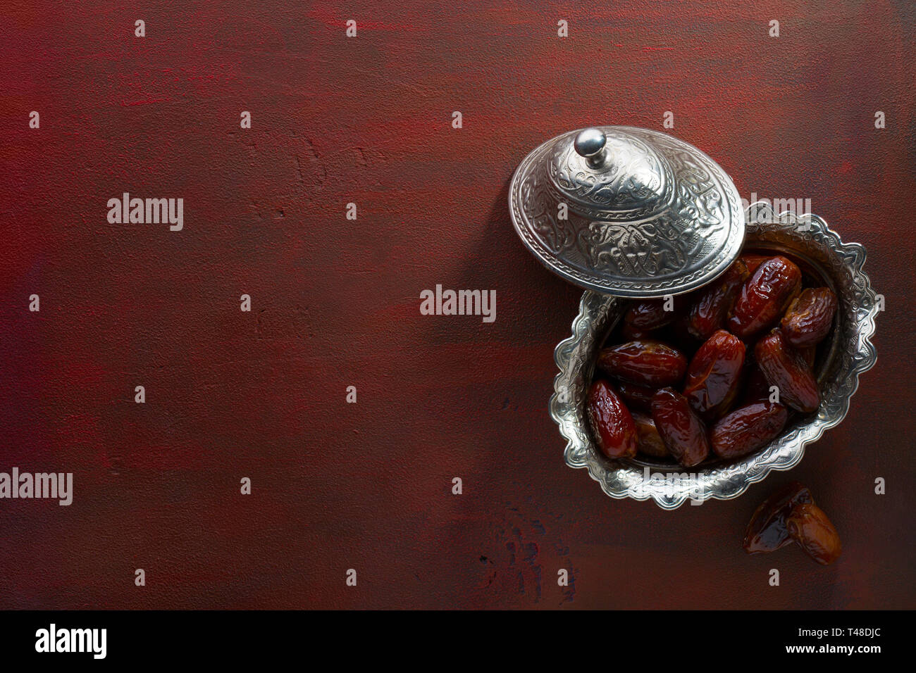 Bowl of dates on a painted red brown wooden table. Top view Stock Photo ...
