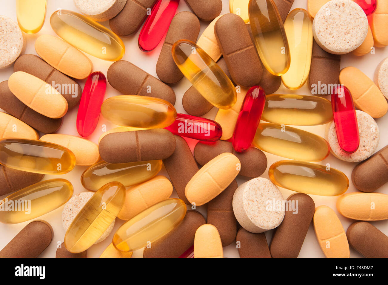 Different medical pills mix on white background Stock Photo - Alamy