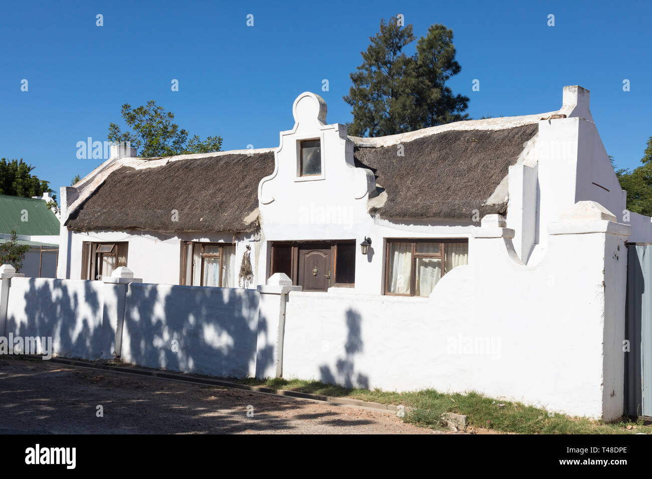 Old historic traditional thatched Cape Dutch cottage with gable in town ...