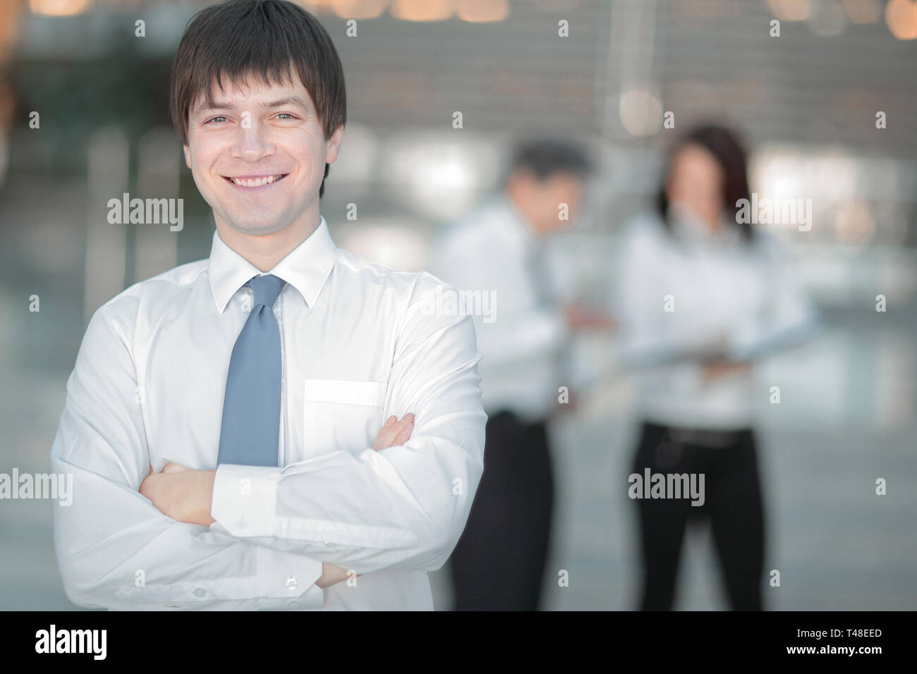 successful young employee on blurred background office.photo with copy ...