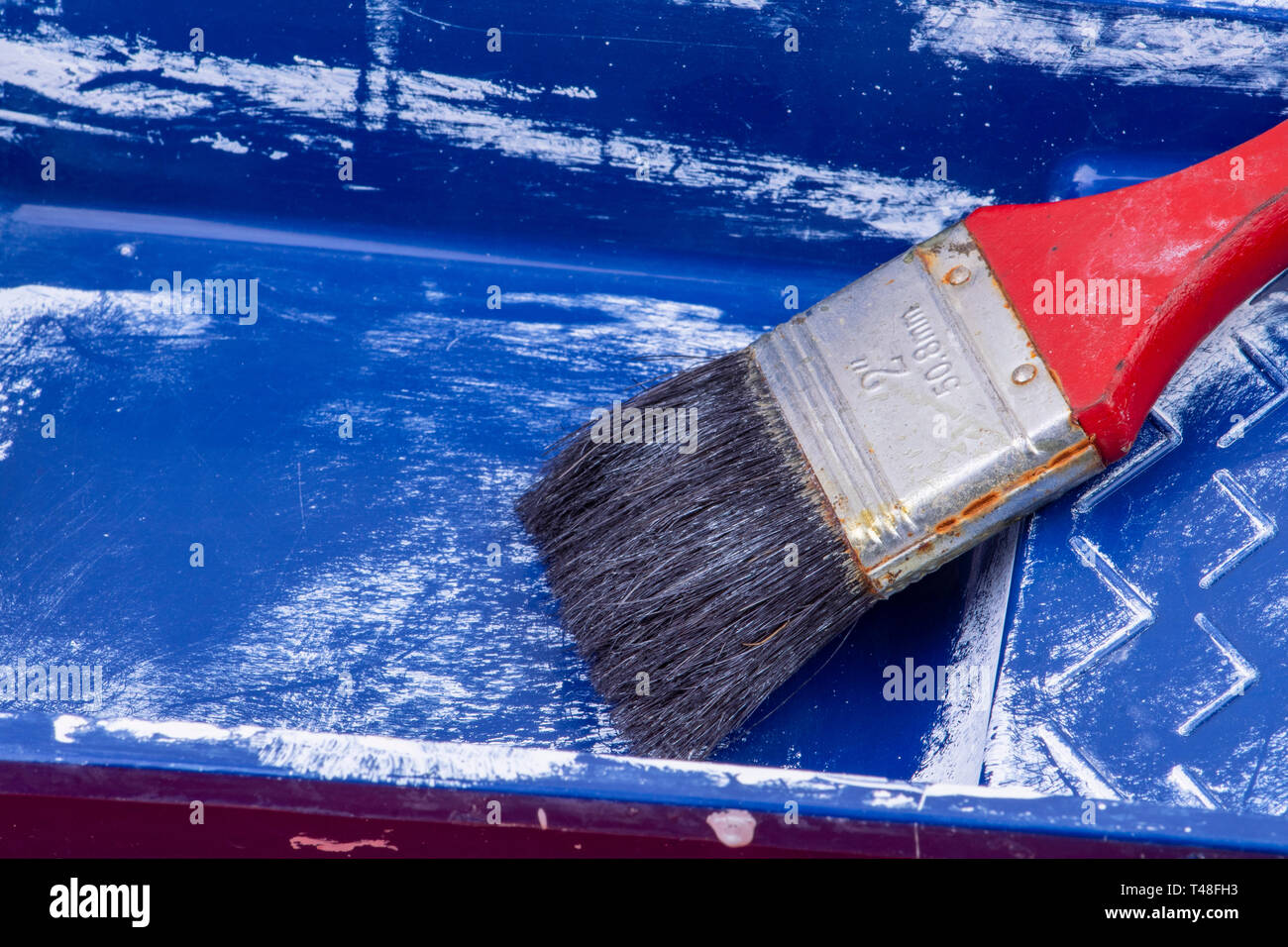 blue paint container with white paint and black brush Stock Photo - Alamy