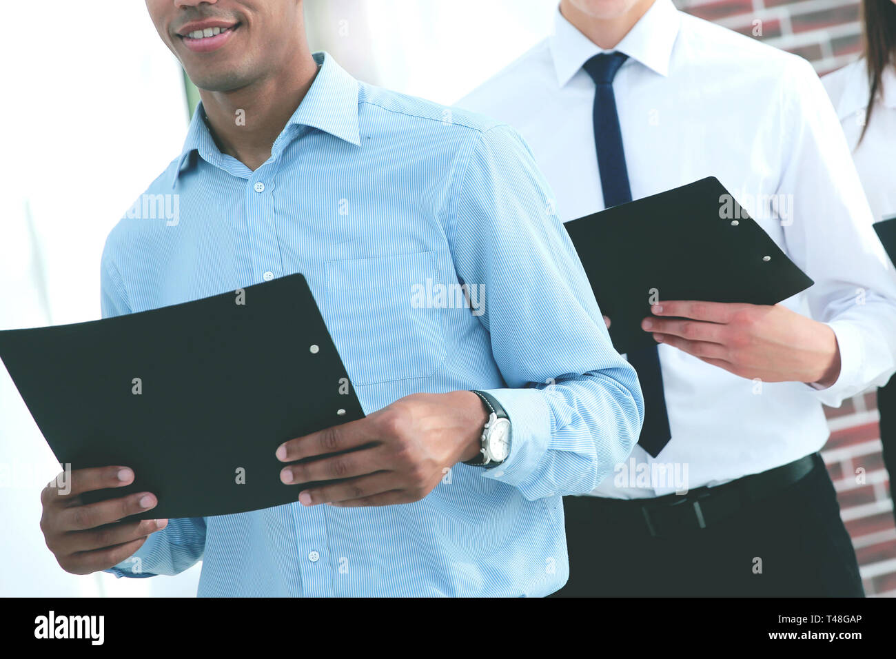 business team holding a copy of the contract, standing in the office ...