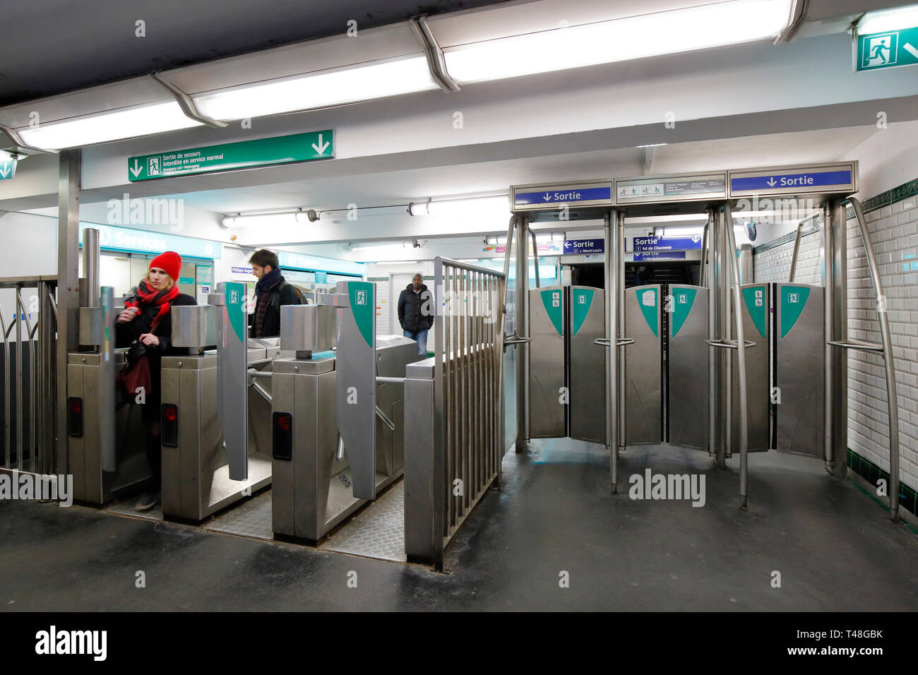 People entering a Paris Metro station through the turnstile, Paris ...