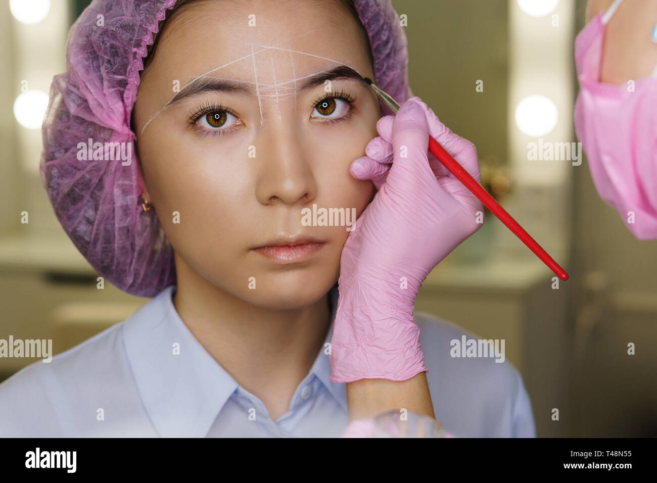 Microbleeding and eyebrow architecture. Cosmetologist applies coloring ...
