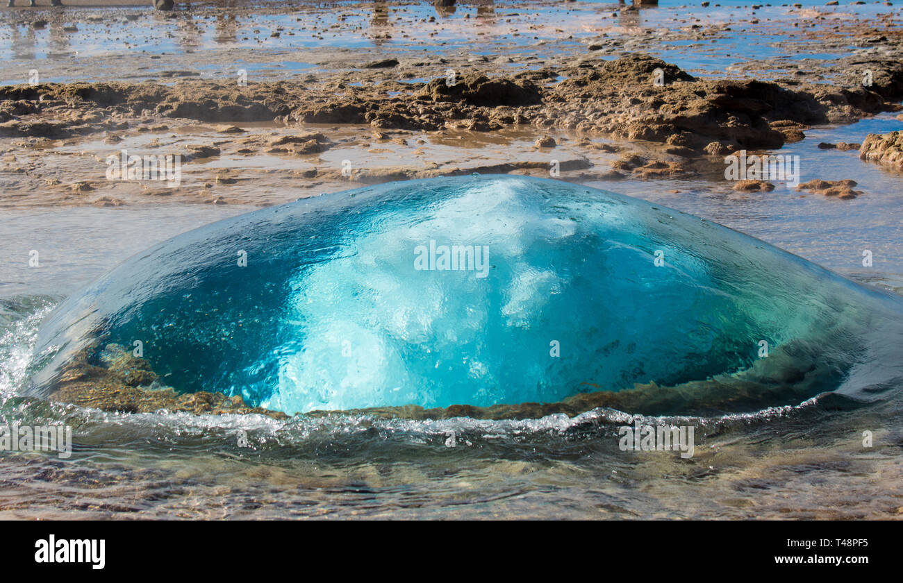 The turquoise blue boiling bubble of Strokkur Geyser In Iceland before ...
