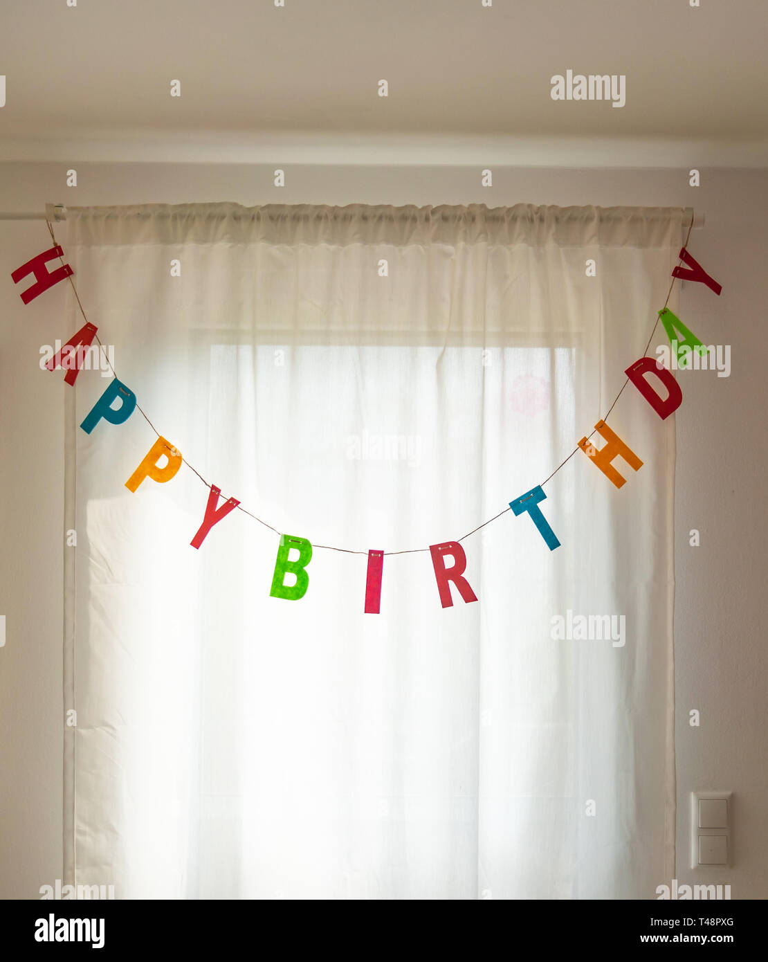 Image of garland with letters Happy Birthday hanging in front of a ...