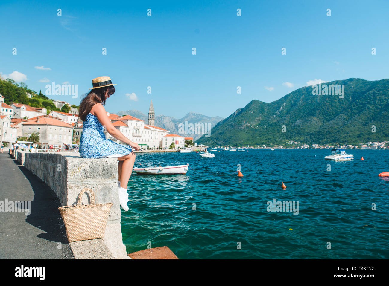 woman walking by Perast city. summer vacation. sea bay. mountains on ...