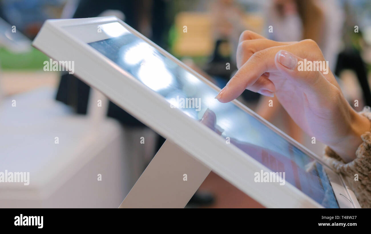 Woman using interactive touchscreen display at urban exhibition Stock ...