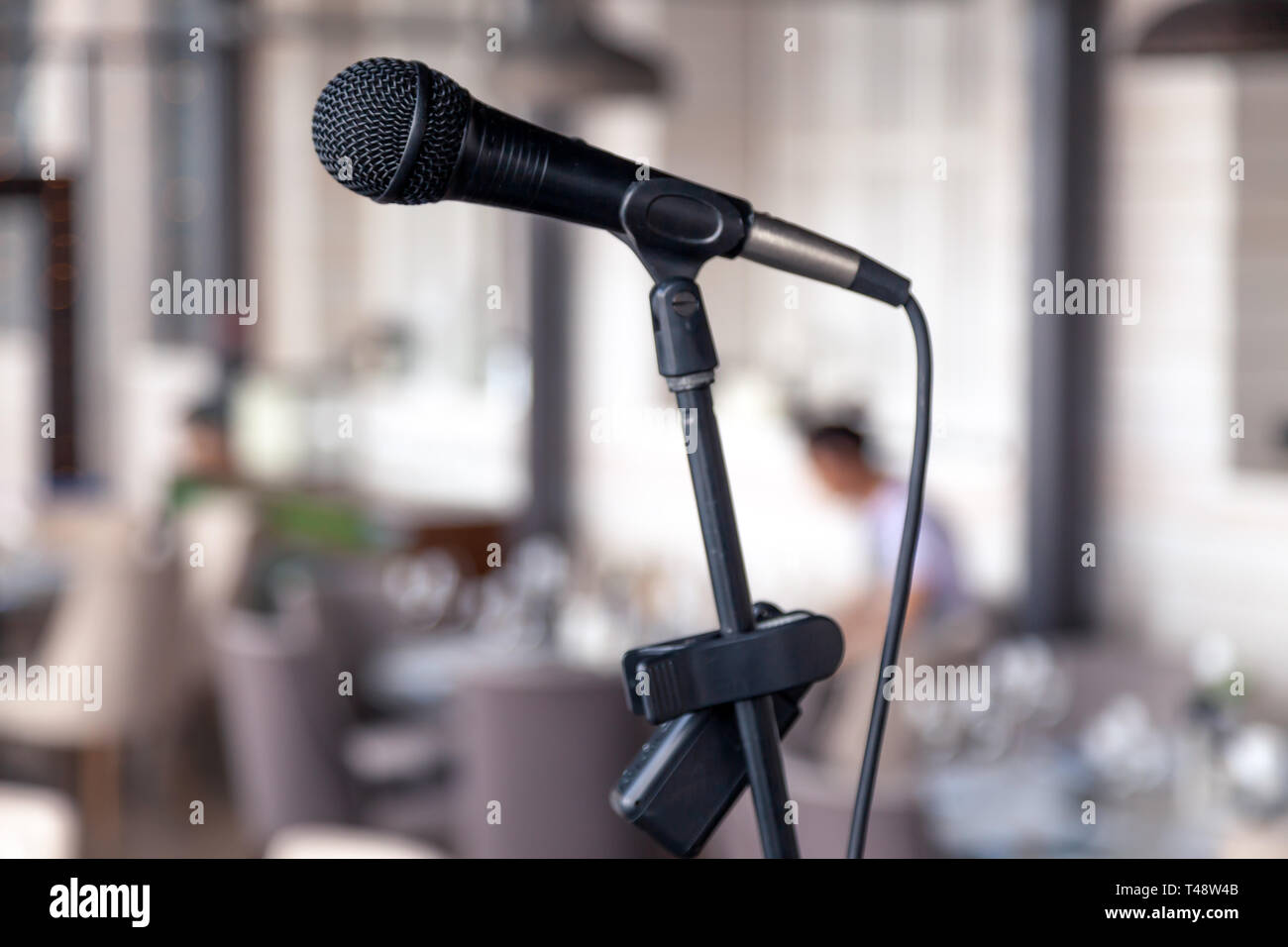 Closeup black iron microphone on stage background of restaurant hall ...