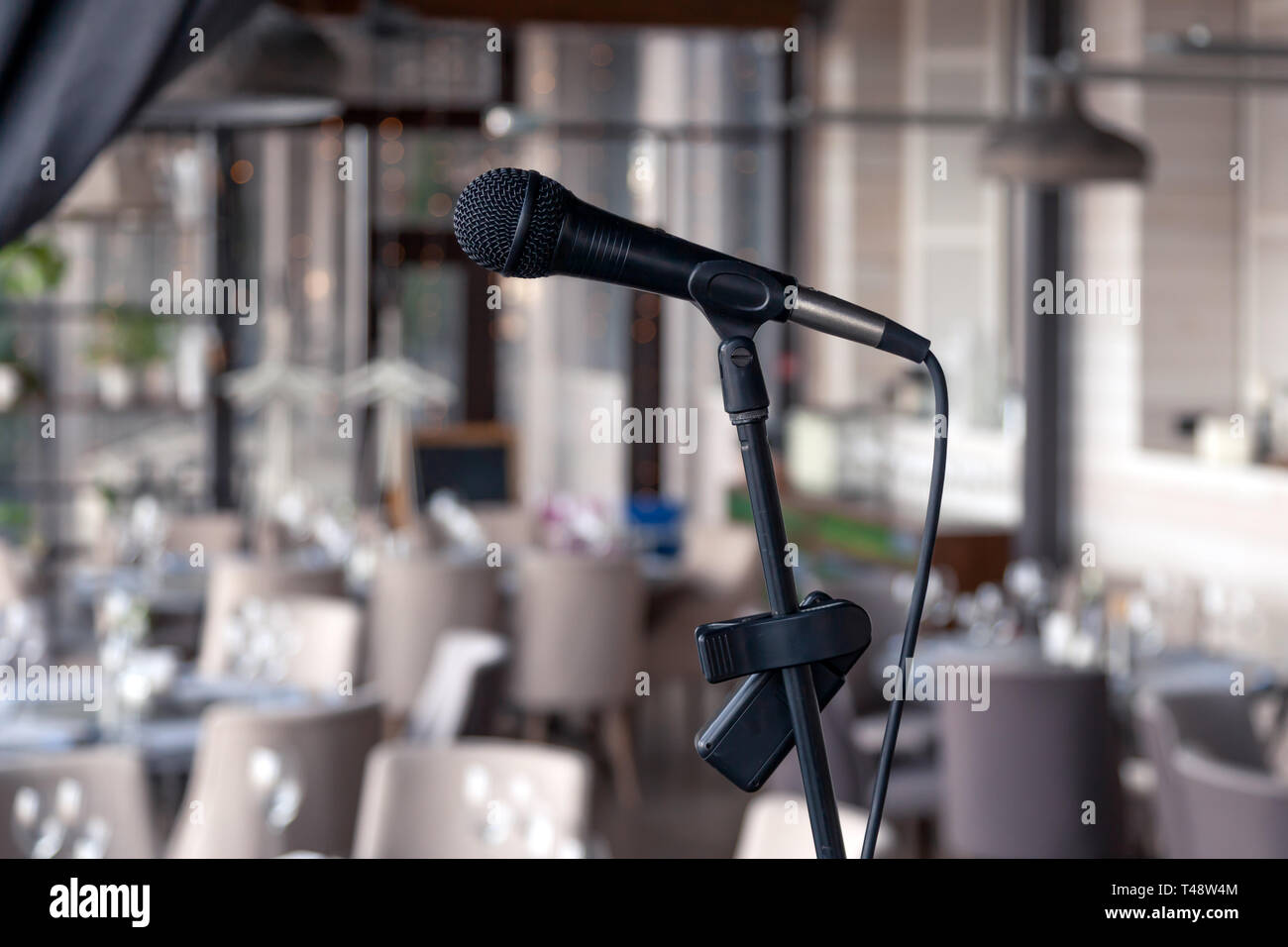 Closeup black iron microphone on stage background of restaurant hall ...