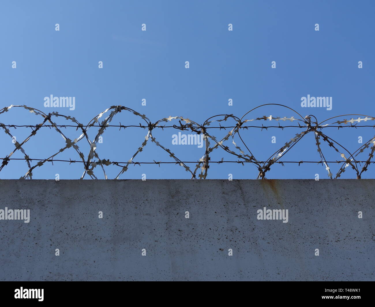 concrete wall with barbed wire razor wire low angle view Stock Photo ...
