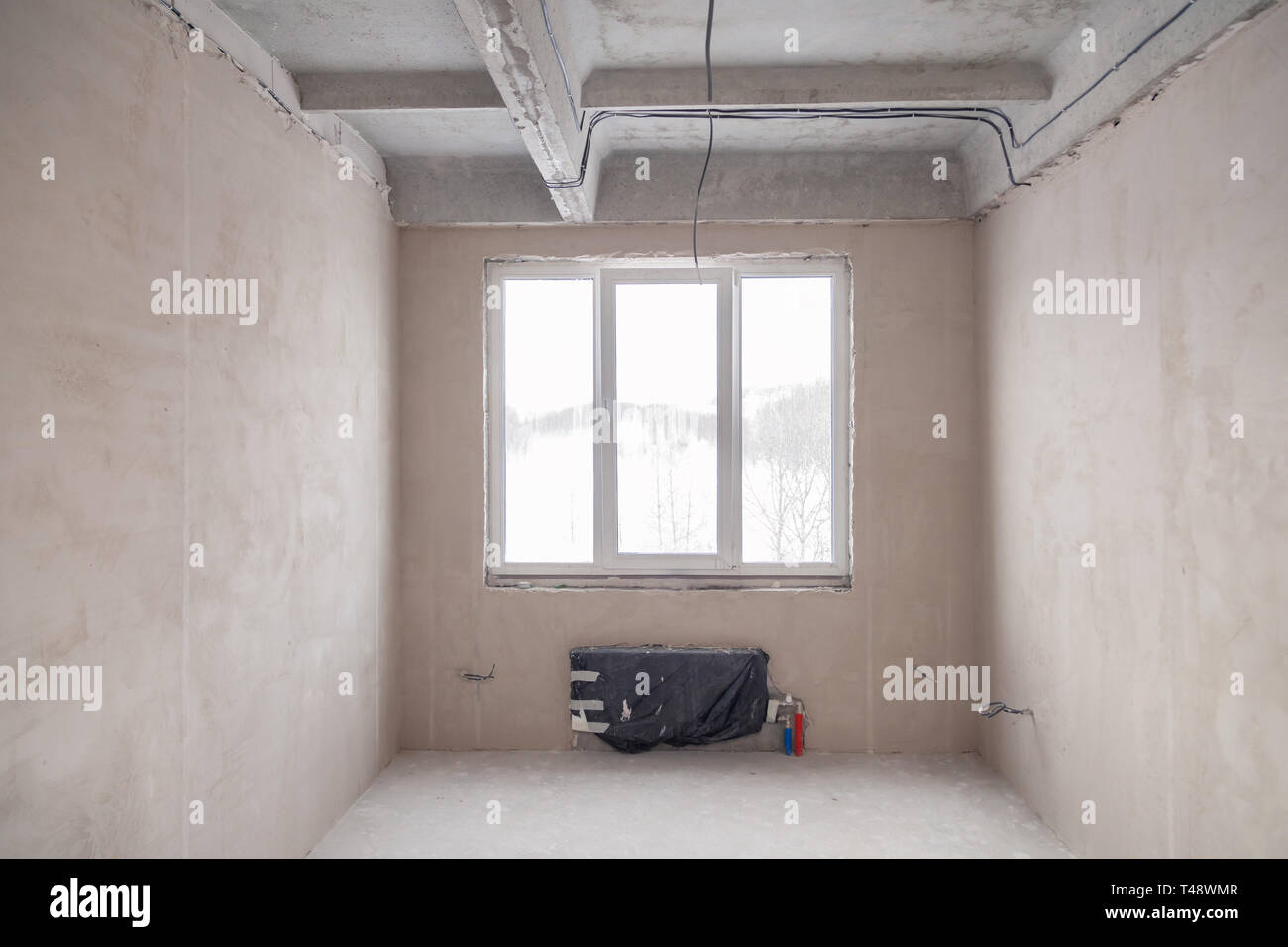 Empty room with a window and a battery in a house under construction ...