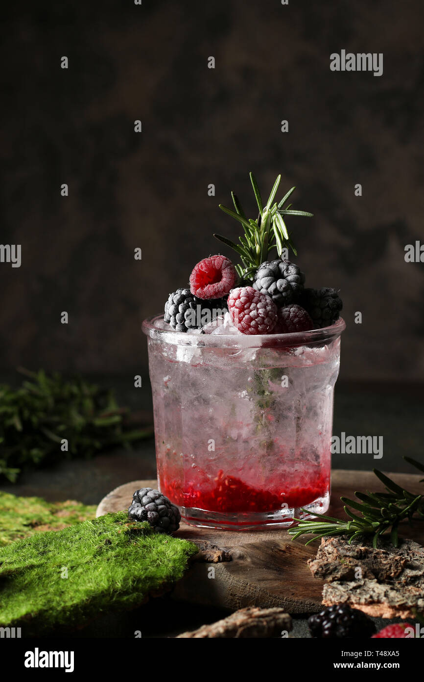 Refreshing summer drink with syrup, raspberry, blackberry and ice on ...