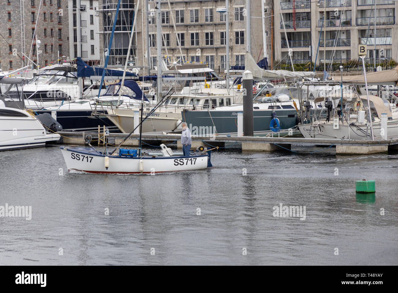 Fisherman drives small fishing boat across Sutton Harbour, Plymouth ...