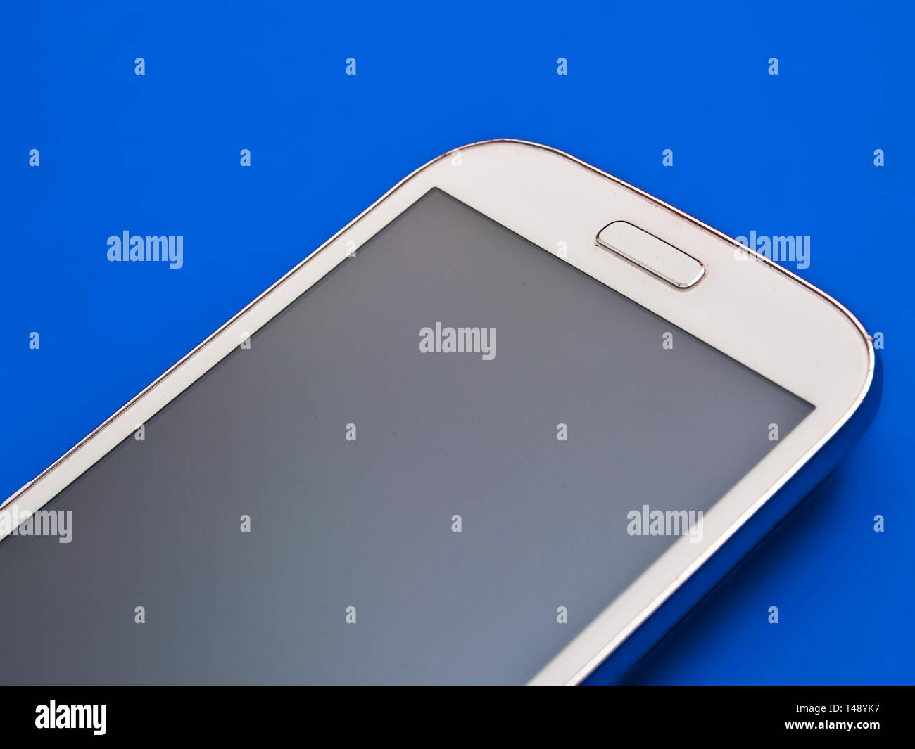 Isolated white cell phone on blue background Stock Photo - Alamy