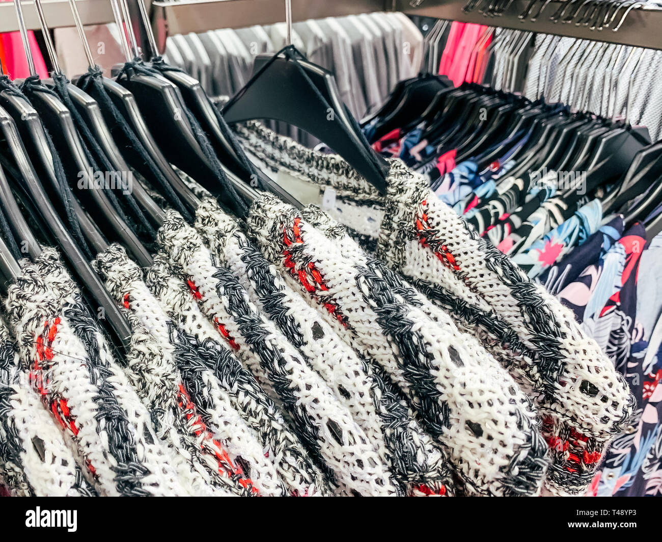 Female Clothes on racks at a Fashion Store. Mobile photo Stock Photo ...