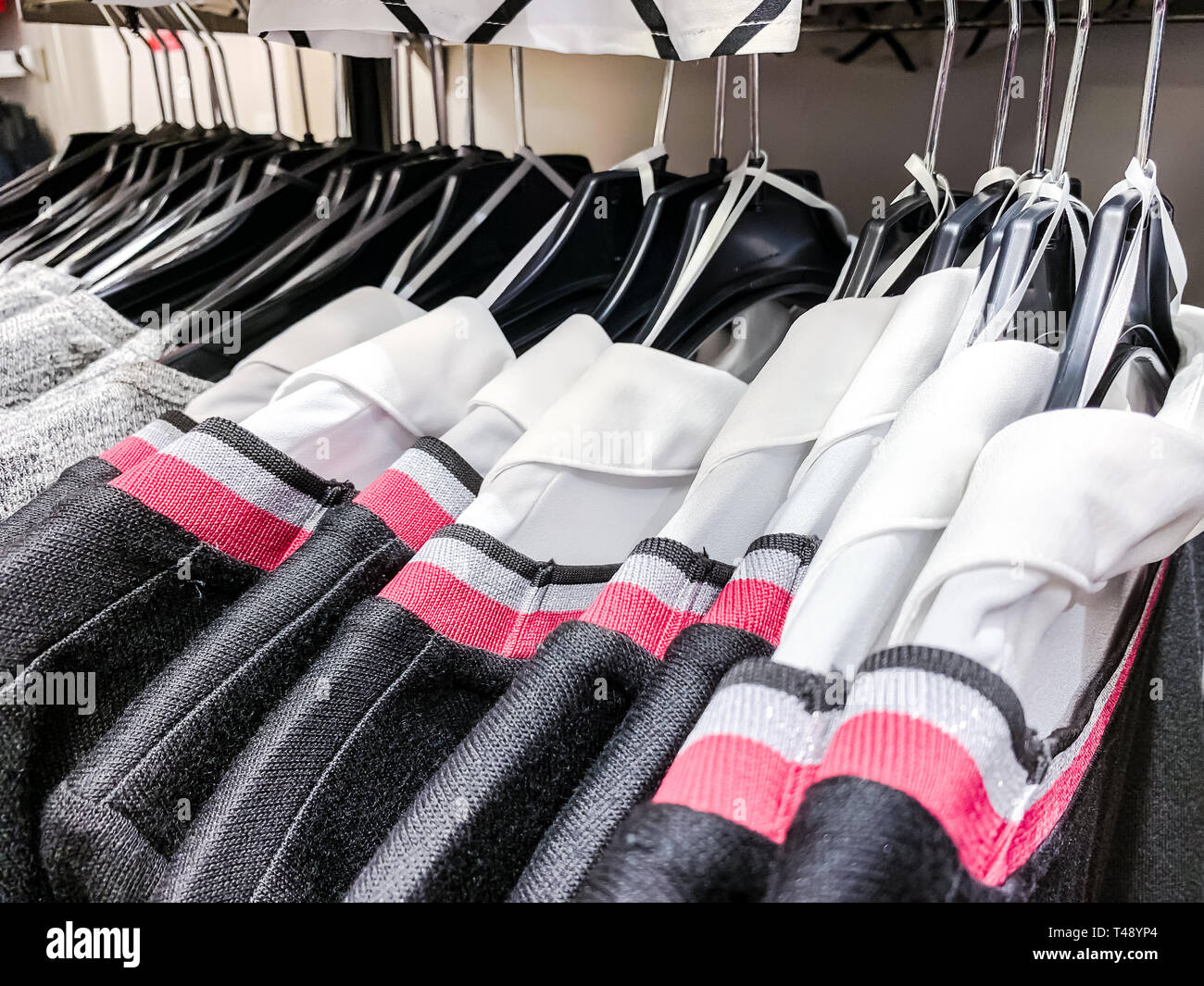 Female Clothes on racks at a Fashion Store. Mobile photo Stock Photo ...