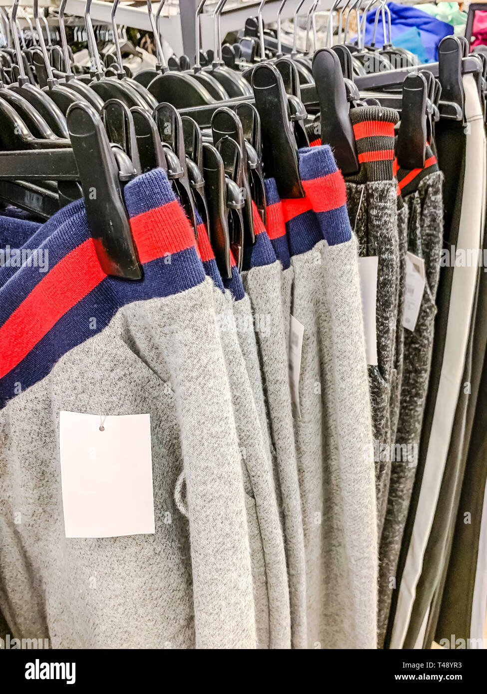 Female Clothes on racks at a Fashion Store. Mobile photo Stock Photo ...