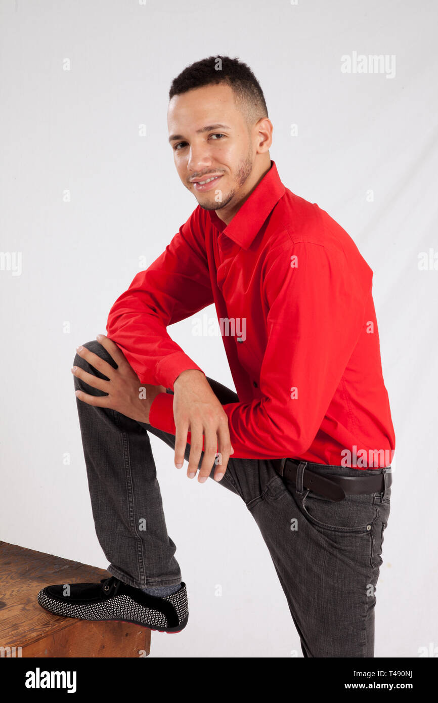 Happy Black man standing with one leg on a table Stock Photo - Alamy