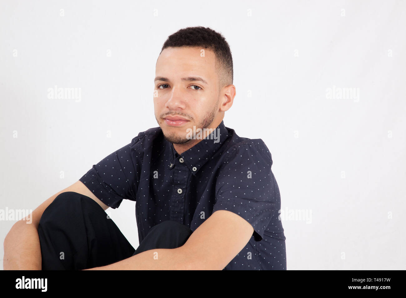 Thoughtful young man sitting Stock Photo - Alamy