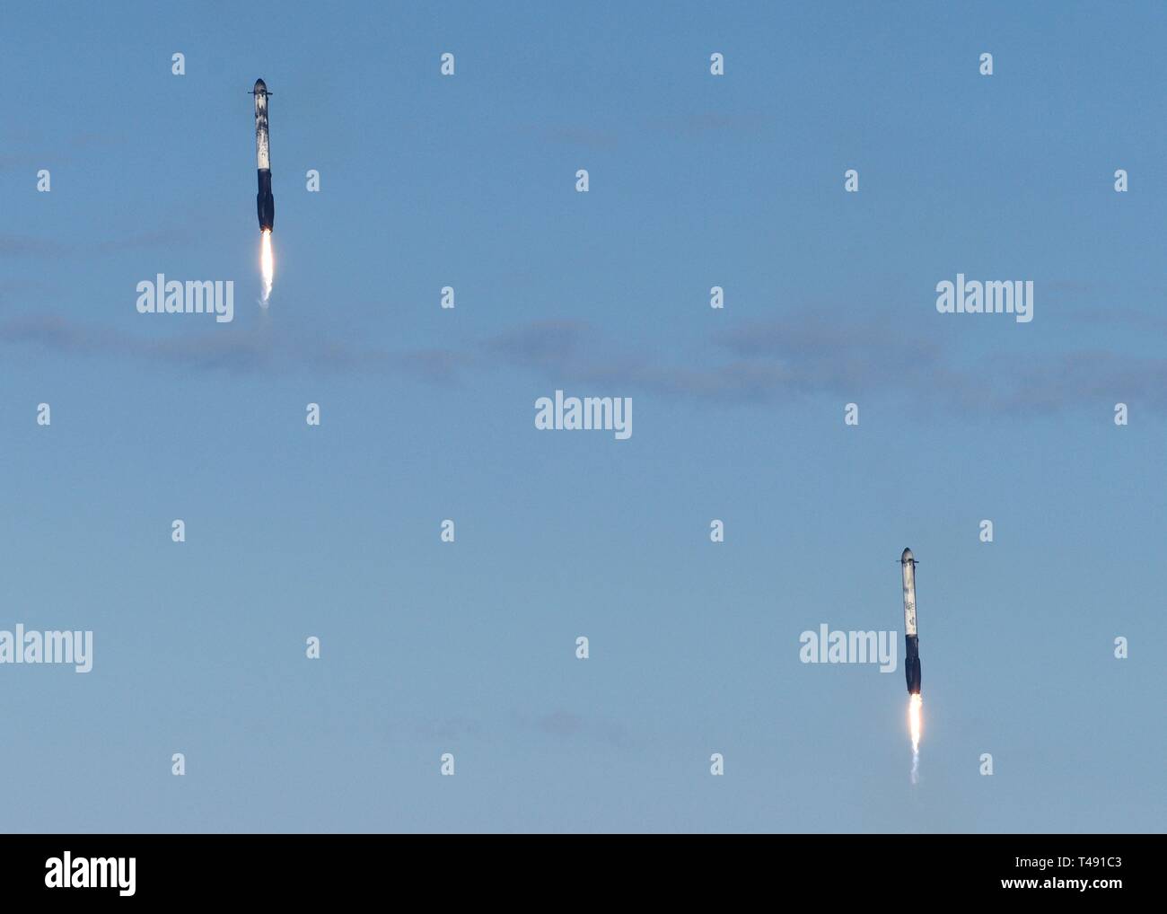 Two SpaceX Falcon Heavy reusable rocket boosters descend to land ...