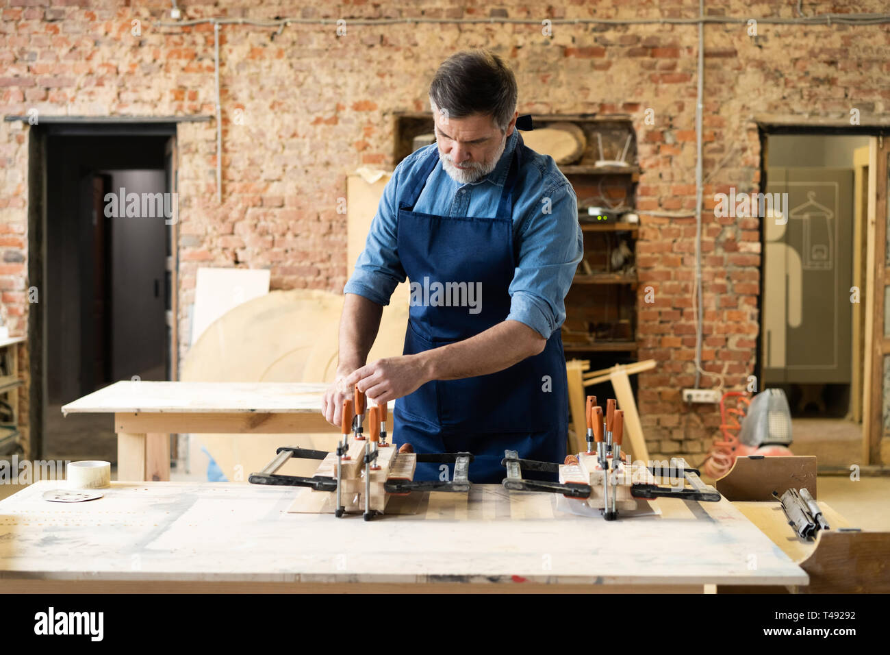 Mature handsome joiner work in carpentry. He is successful entrepreneur ...