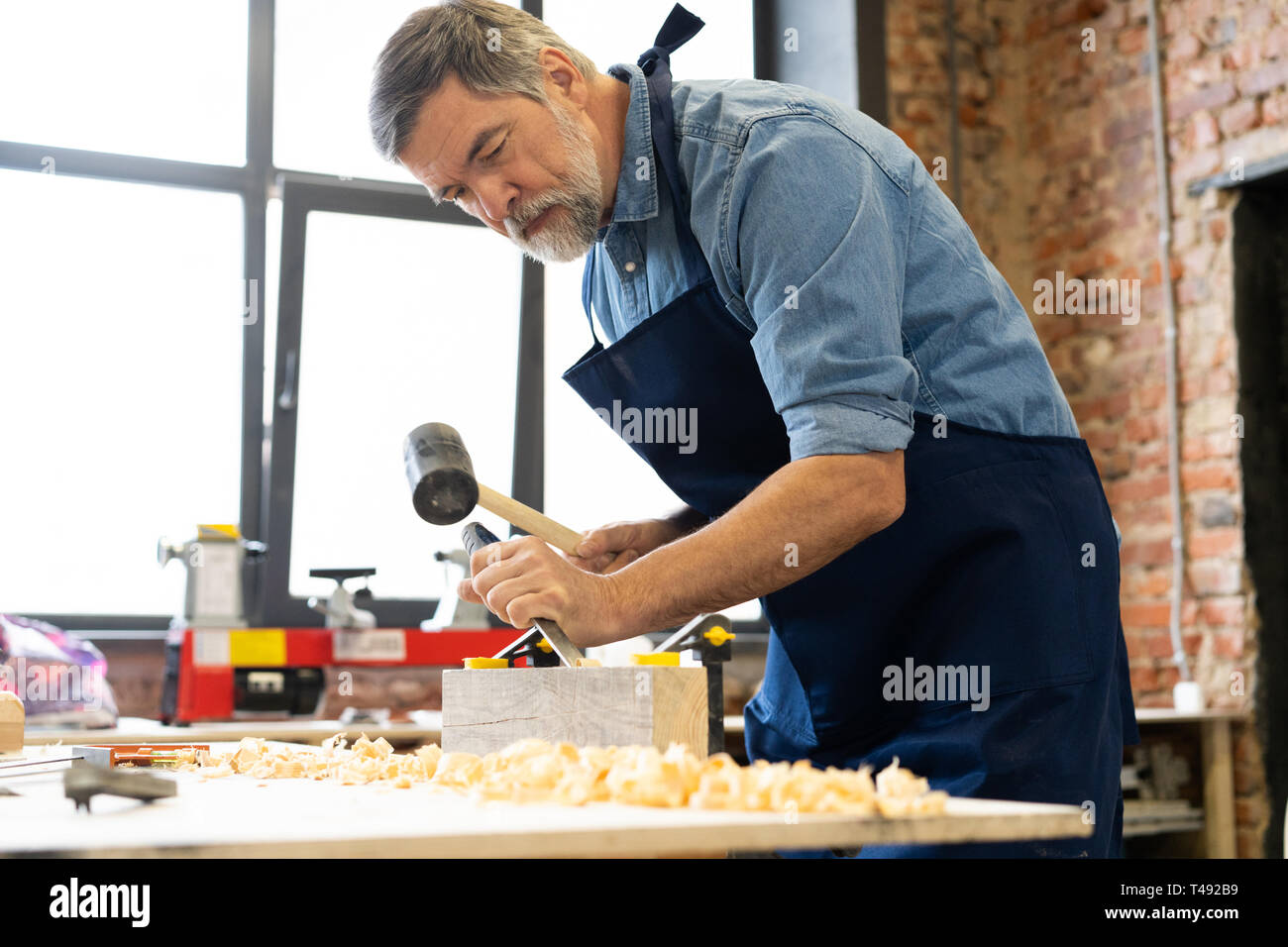 Mature handsome joiner work in carpentry. He is successful entrepreneur ...