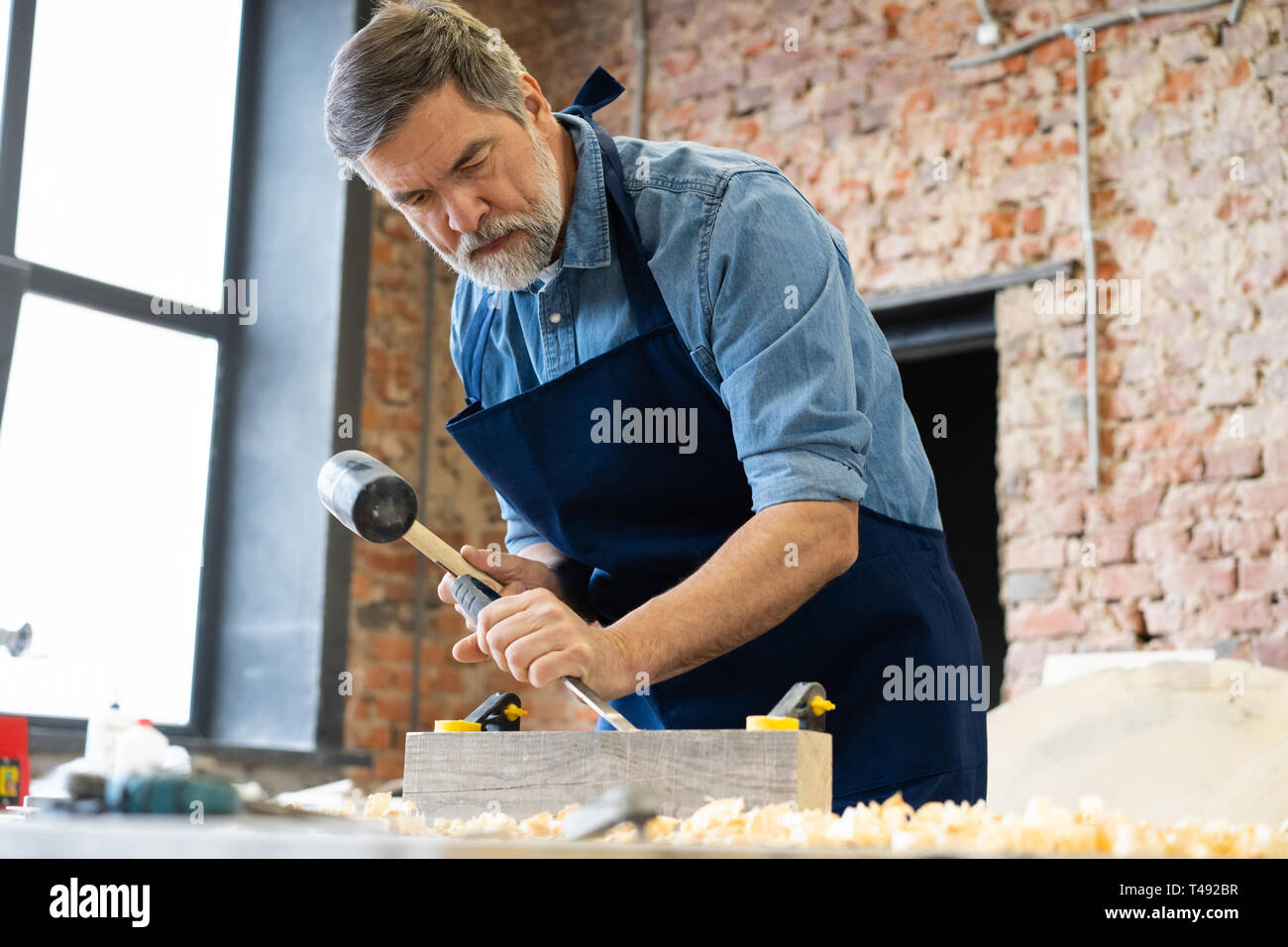 Mature handsome joiner work in carpentry. He is successful entrepreneur ...