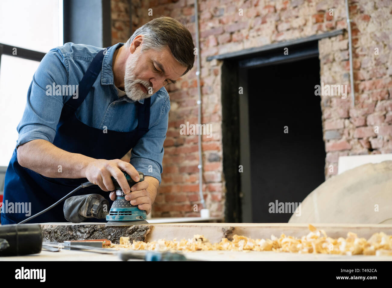 Mature handsome joiner work in carpentry. He is successful entrepreneur ...