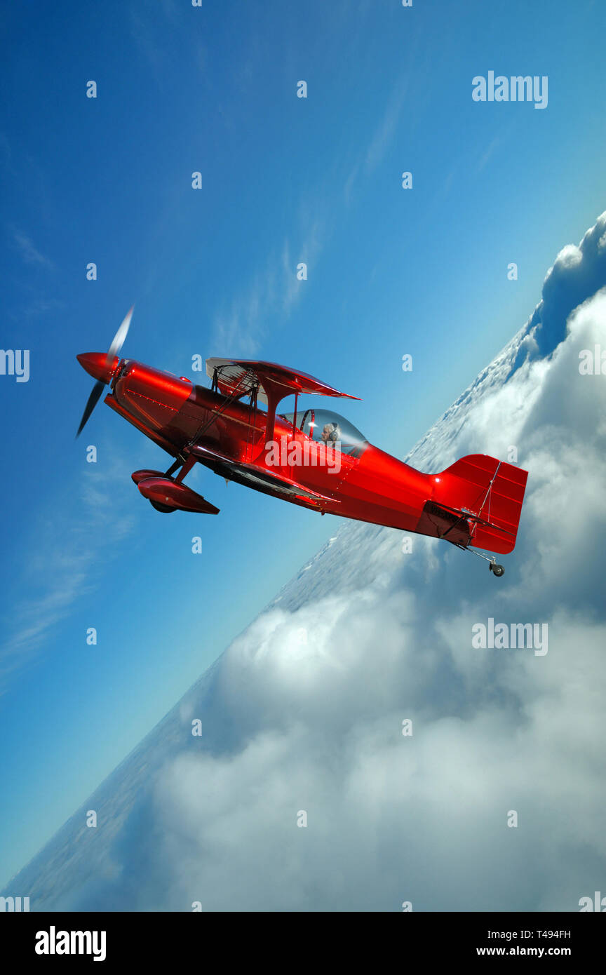 A portrait air to air shot of a red Pitts aerobatic biplane in a ...