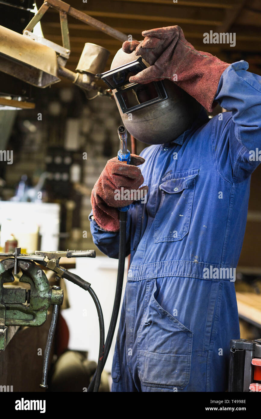 Welder is welding in the garage,industrial Worker labourer at the ...