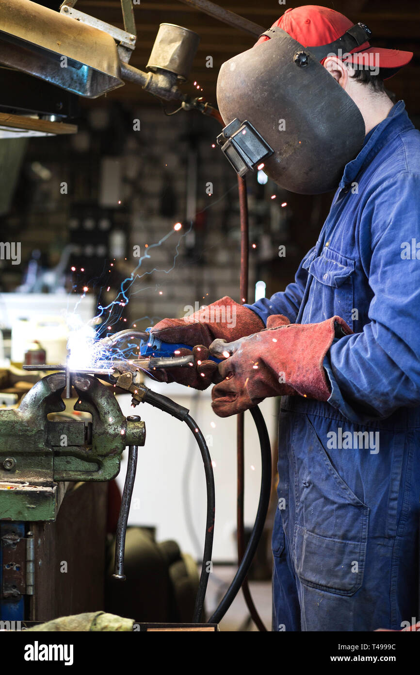 Welder is welding in the garage,industrial Worker labourer at the ...