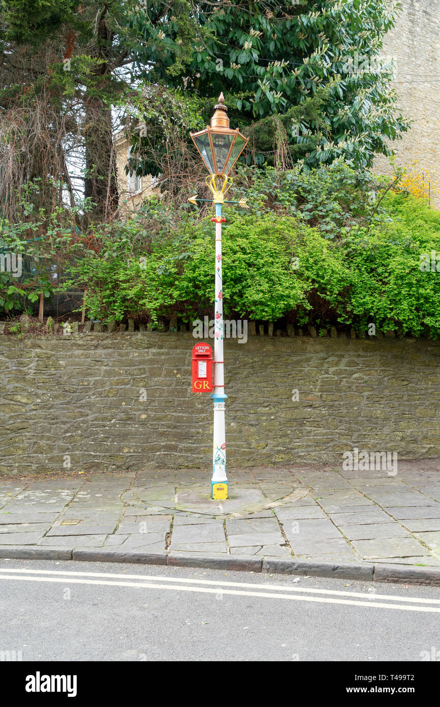 Painted decorative lamp post with bright red post box attached Stock ...