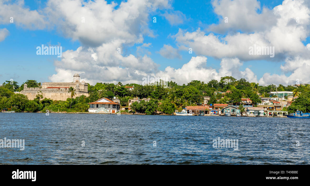 Cuban fishing boats and village houses with Jagua Spanish castle walls ...