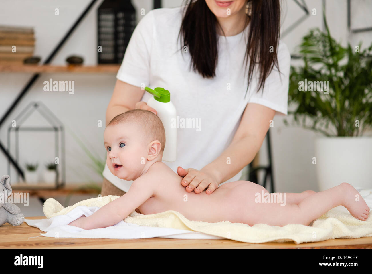 Happy baby girl during massage by young mother Stock Photo - Alamy